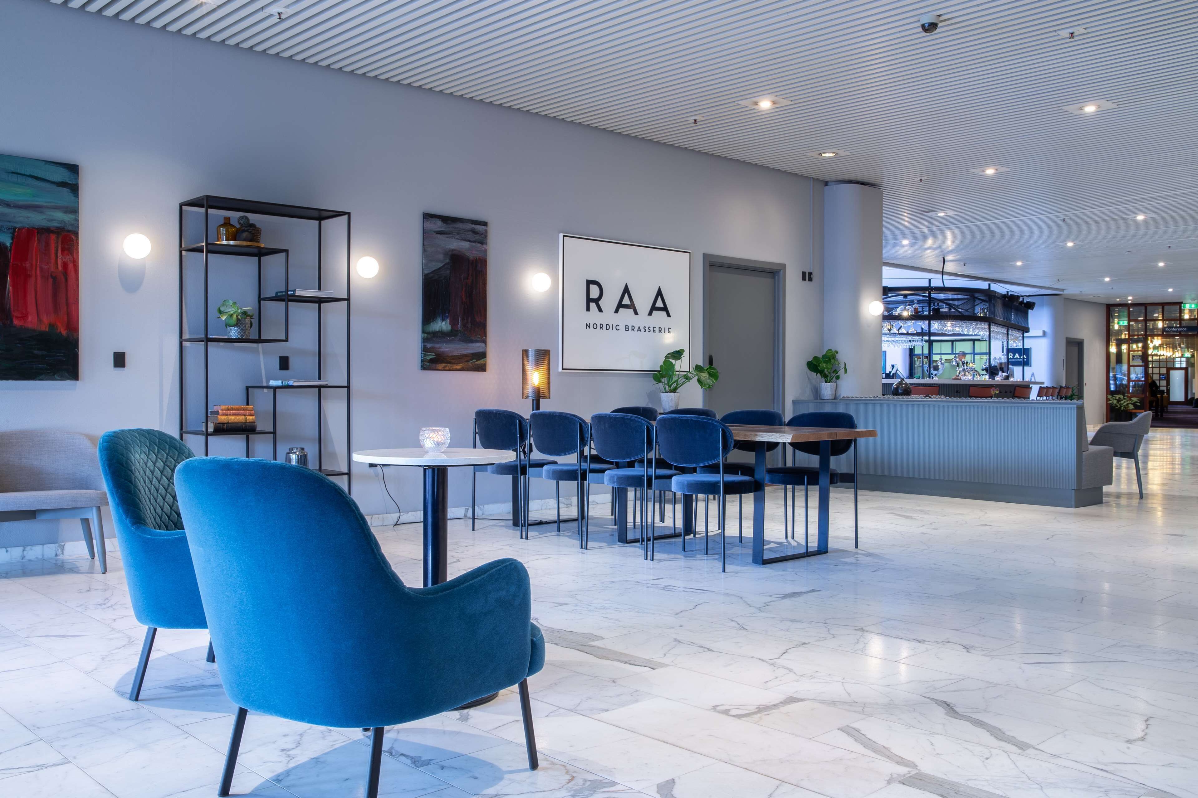 Um interior moderno com balcão de recepção, área de estar e bar.