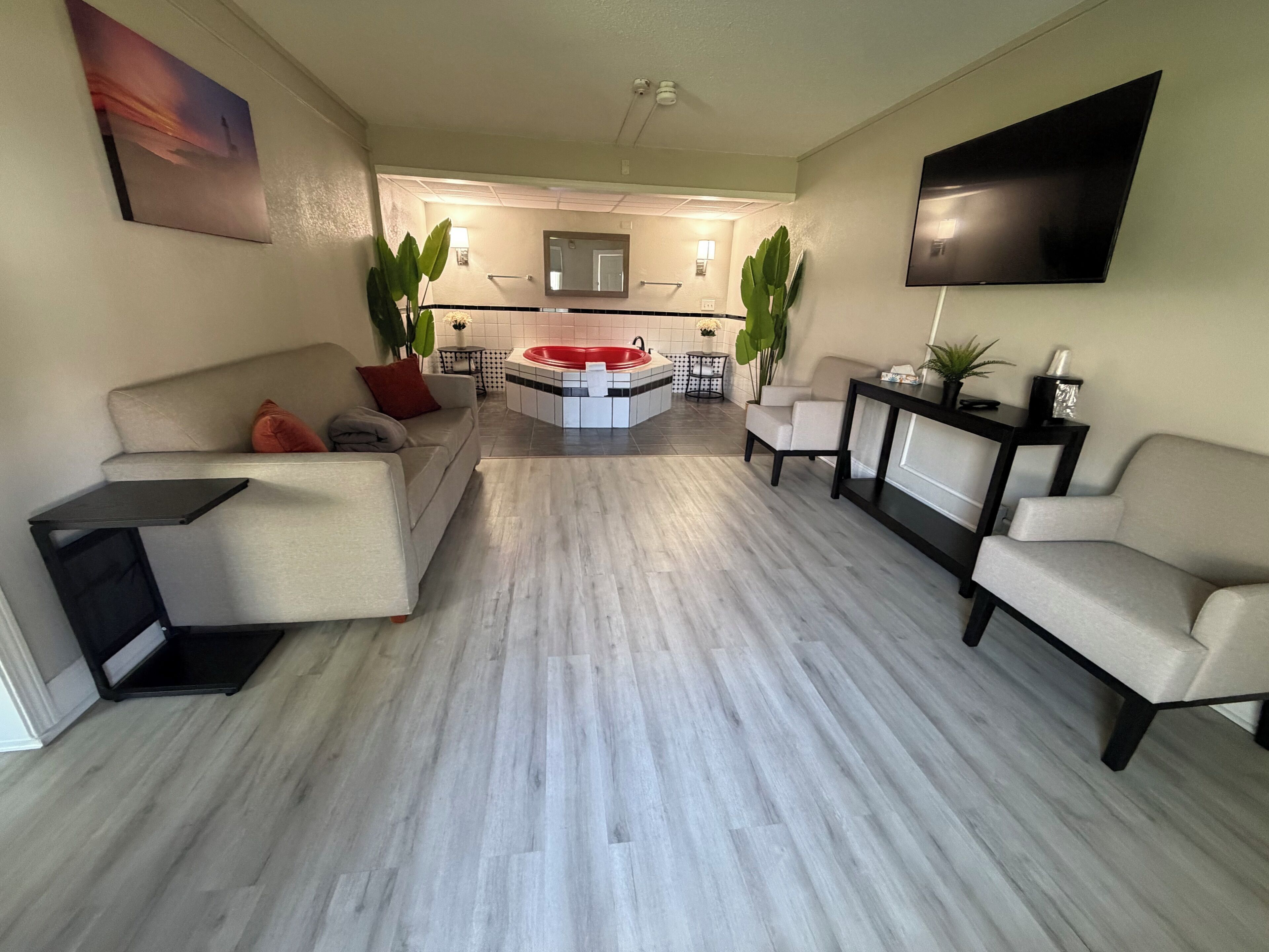 Uma sala de estar moderna com um sofá, poltronas, uma mesa de centro, uma televisão e uma lareira.