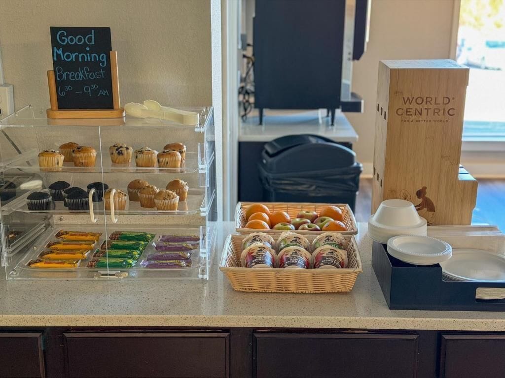 Um balcão de café da manhã com muffins, doces e potes de iogurte.
