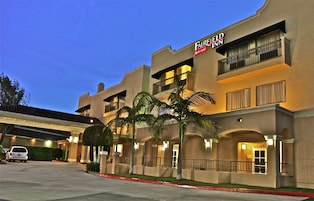 Um hotel com vários andares e uma placa chamativa com a inscrição 'Fairfield Inn'.