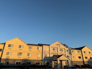 Um hotel de vários andares com telhado plano e entrada central.