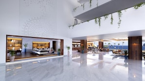 Um hall amplo com design moderno, com área de estar, um bar e vista para o oceano.