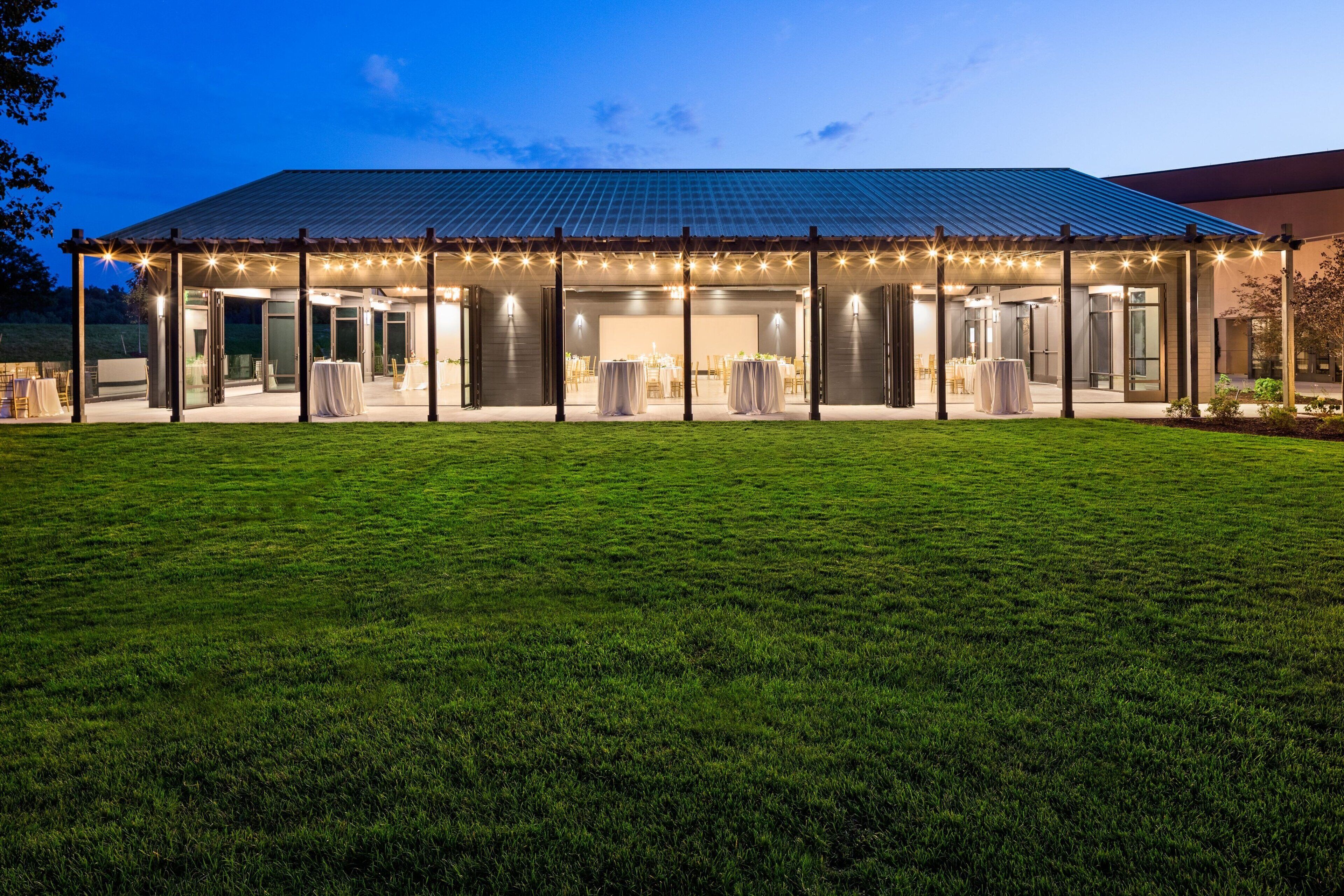 Uma área externa coberta com mesas e cadeiras, provavelmente para refeições ou eventos.