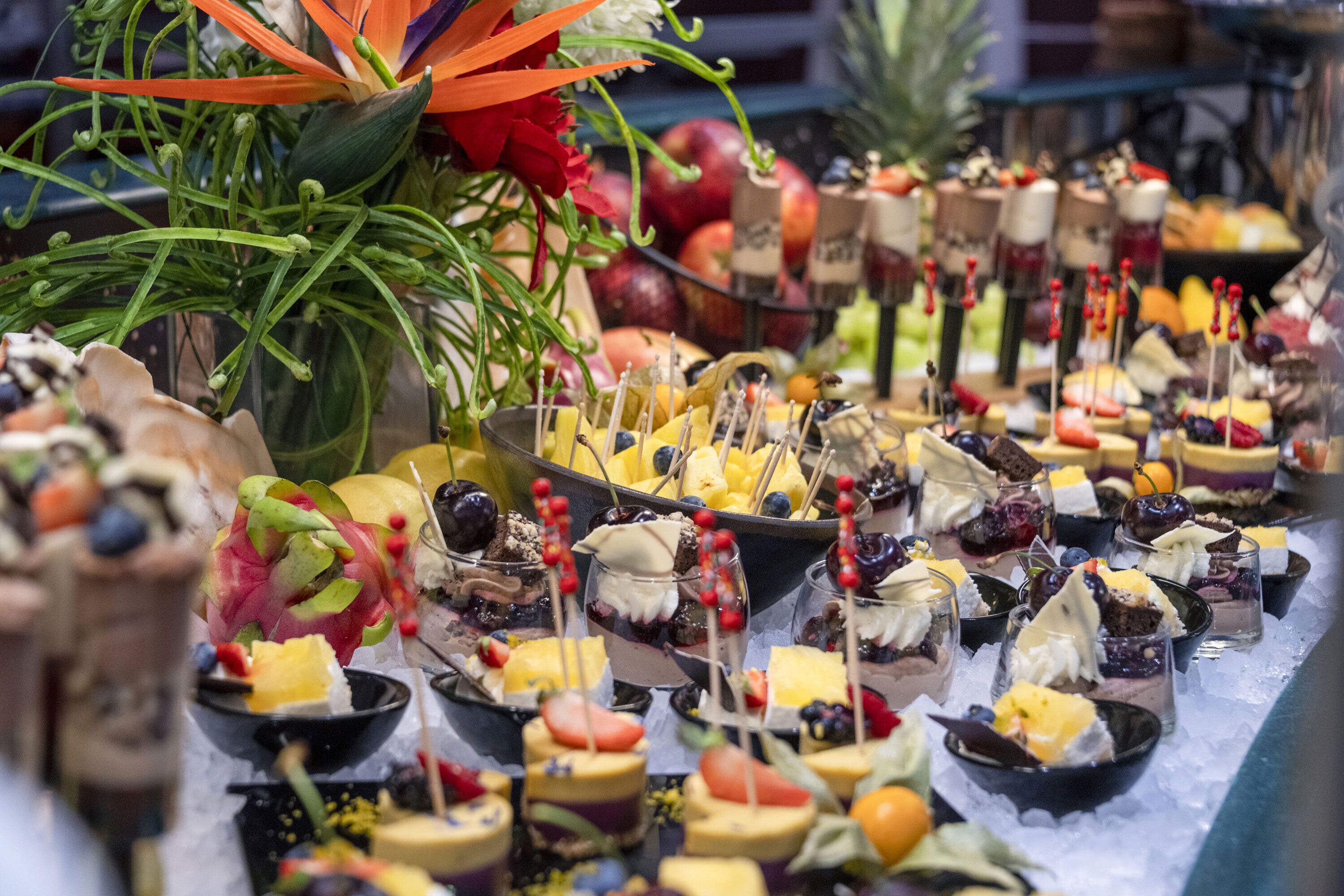 Um buffet com diversos doces e frutas.