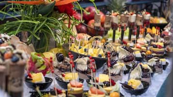 Um buffet com diversos doces e frutas.