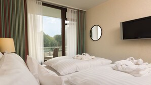 Quarto de hotel com duas camas, televisão, espelho e varanda com cortinas.