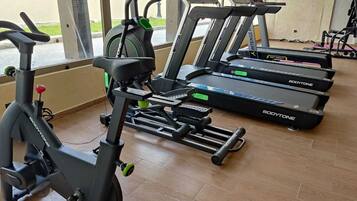 Uma academia com esteiras, elíptico e bicicleta ergométrica.