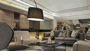 Uma sala de estar moderna com um conjunto de sofás, uma mesa de centro e um lustre.
