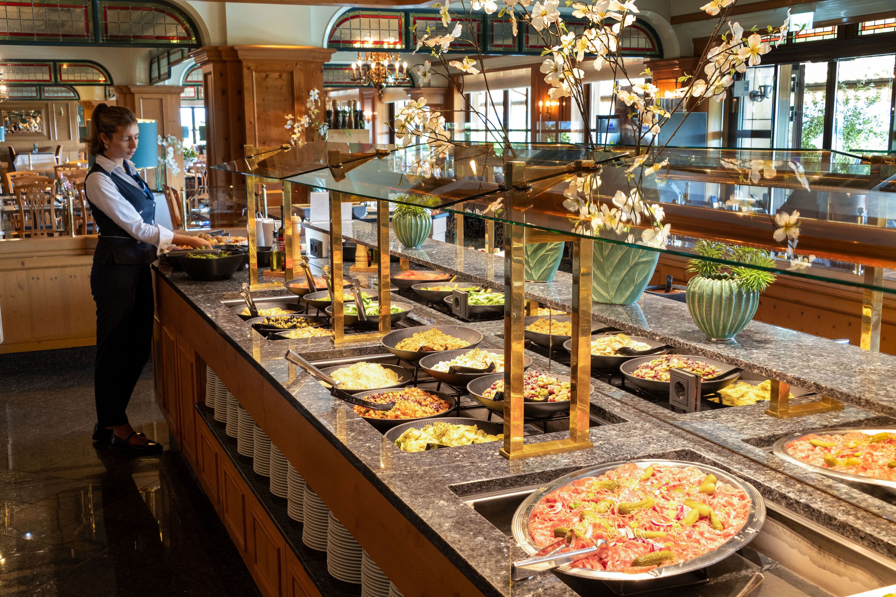 Uma mesa de buffet com diversos alimentos e um balcão de serviço.