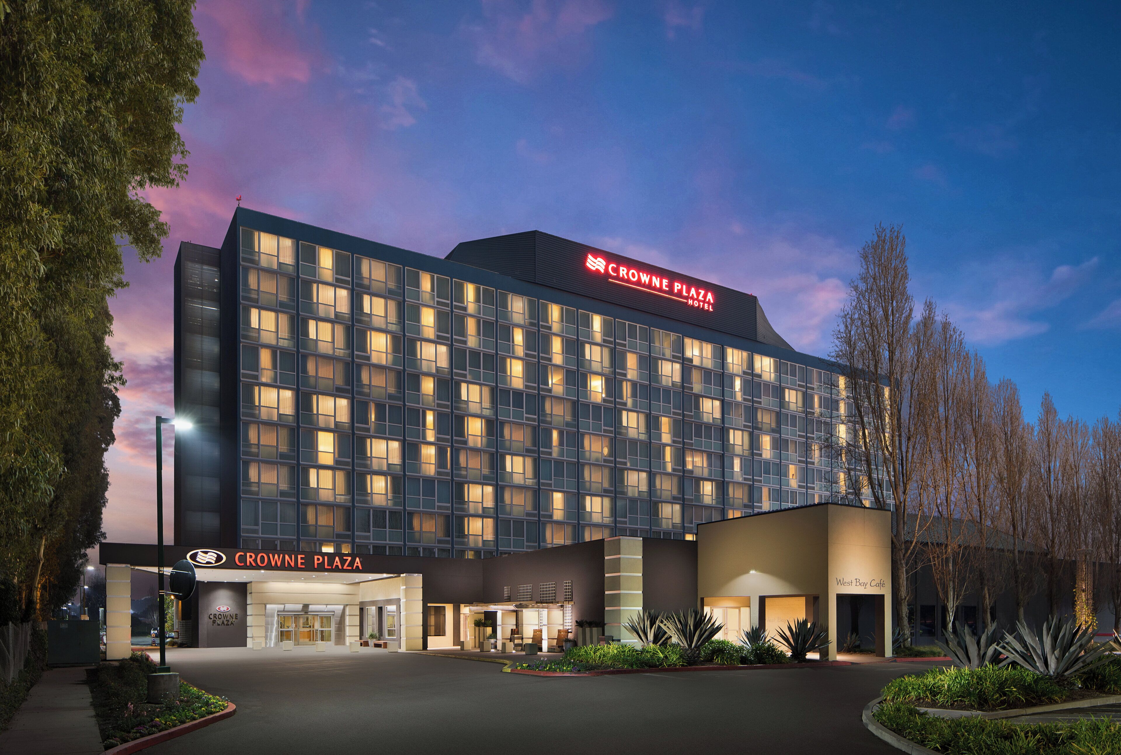 Hotel com fachada moderna, vários acessos e entrada bem iluminada.