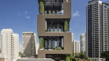 Um hotel Pan Pacific moderno, com um design escalonado singular, apresentando vários níveis e abundante uso de vidro e vegetação.