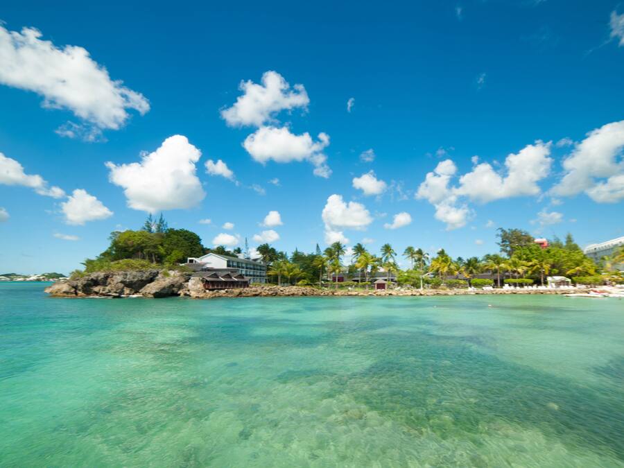 Na praia, areia branca, espreguiçadeiras, guarda-sóis