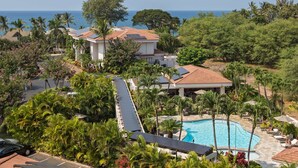 Um resort com piscina, painéis solares e vista para o oceano.