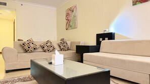 Uma sala de estar com dois sofás, uma mesa de centro e um quadro na parede.