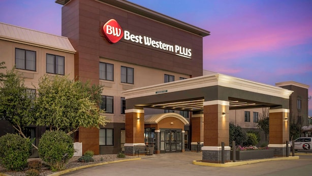Um hotel Best Western PLUS com fachada moderna, entrada coberta e um jardim frontal ajardinado.