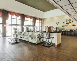 Um hall amplo com sofá, poltronas e um espaço para café.