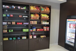 Máquina de vendas automática com variedade de lanches e bebidas.
