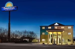 Um hotel Days Inn com uma placa visível, um edifício de dois andares e uma entrada bem iluminada.