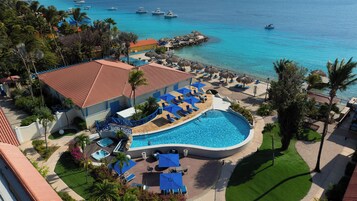 Um resort com uma piscina grande, espreguiçadeiras e vista para o mar.