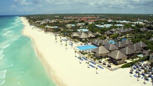 Um resort com acomodações na praia, piscina e acesso direto à praia.