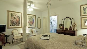 Quarto com uma cama grande, uma cadeira, uma cômoda e uma televisão.