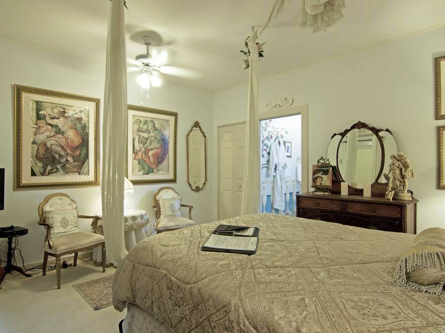Quarto com uma cama grande, uma cadeira, uma cômoda e uma televisão.