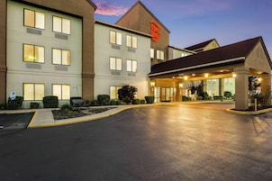 Um hotel com fachada moderna, entrada acolhedora e área de estacionamento.