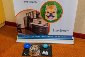 Exposição promocional de um espaço que aceita animais de estimação, com cozinha, comedouro para pets e brinquedo.