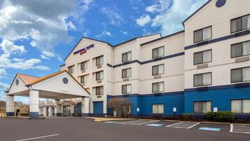 Um hotel Shingled Suites com entrada coberta, vários andares e estacionamento.