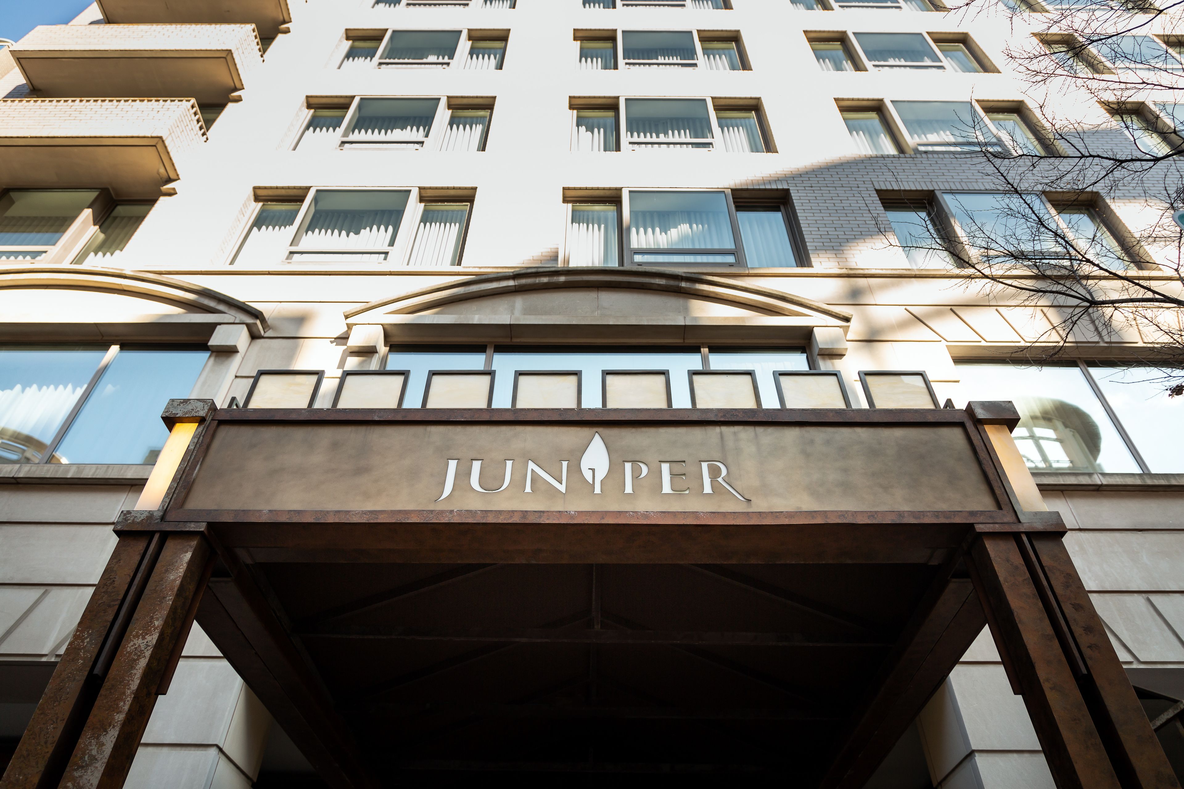 A entrada de um edifício com o nome "JUNIPER" em destaque.