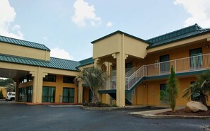 Um hotel de dois andares com telhado plano e entrada coberta.