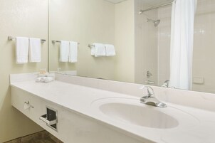 Suite, 1 cama king-size, frigorífico e micro-ondas | Casa de banho | Uma combinação polibã/banheira, um secador de cabelo 