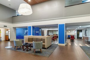 Um hall amplo com área de estar, balcão de recepção e sala de jantar.