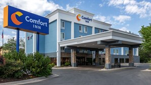 Um hotel Comfort Inn com entrada desimpedida, placa de identificação e área de estacionamento coberta.