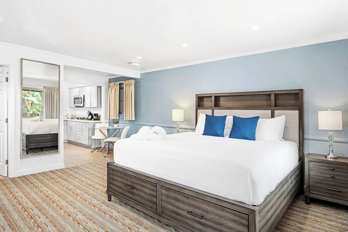 Quarto de hotel moderno com uma cama grande, uma escrivaninha e um banheiro.