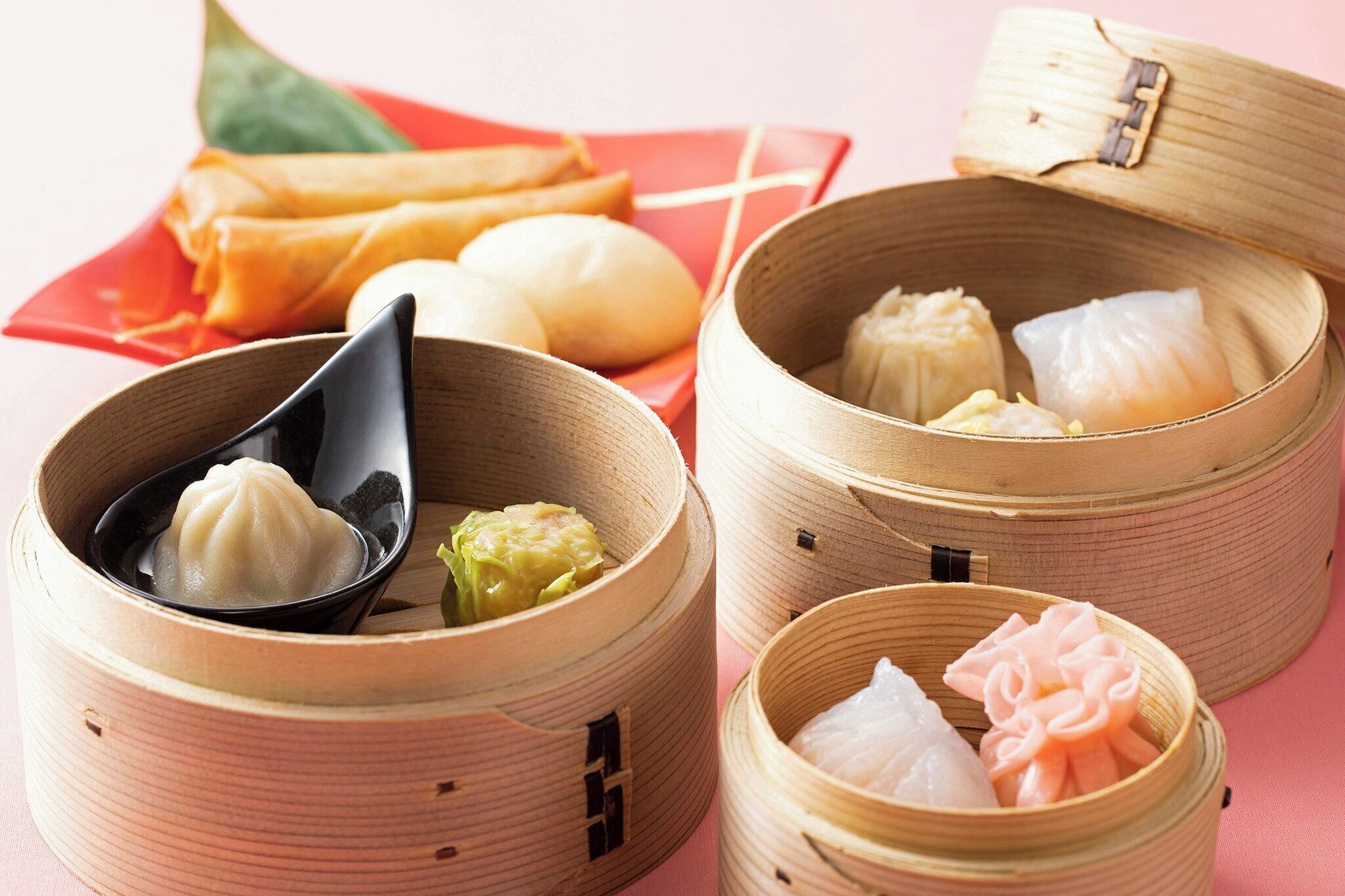 Diversos tipos de dumplings asiáticos tradicionais em cestos de bambu.