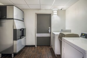 Uma cozinha compacta com geladeira, cafeteira e máquina de lavar.