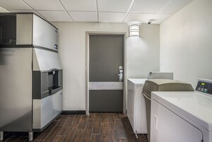 Uma cozinha compacta com geladeira, cafeteira e máquina de lavar.