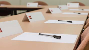 Uma sala de conferência com mesas, cartões de nome e canetas.
