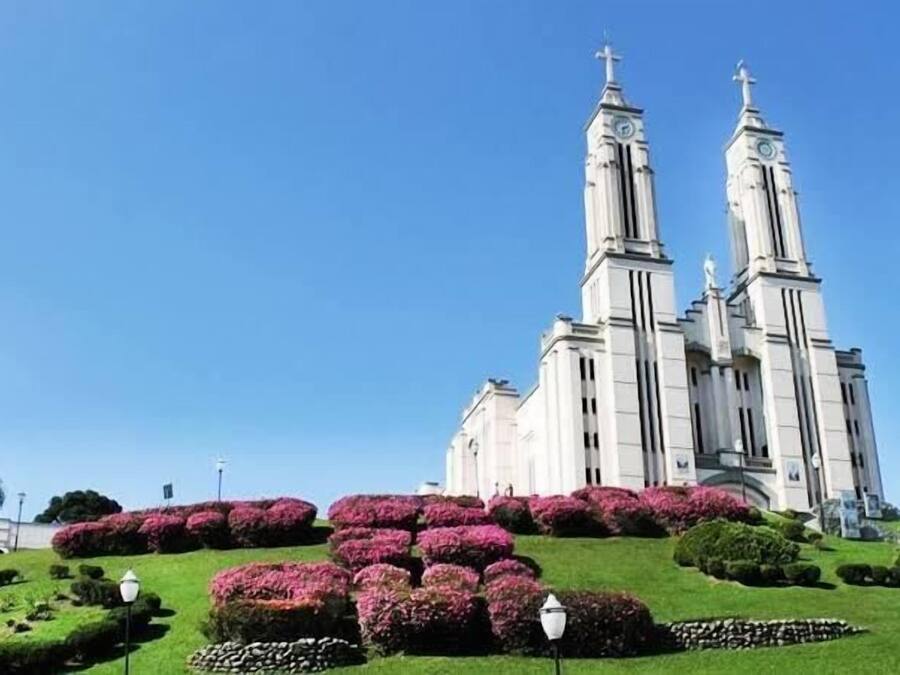 Uma igreja grande com duas torres altas e um relógio em cada torre.
