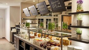 Uma área de buffet com diversos tipos de comida e uma vitrine de vidro.