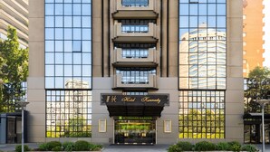 Um hotel moderno com entrada imponente, grandes janelas e placa da Wyndham Garden.