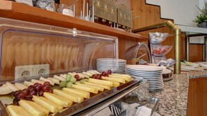 Uma área de buffet com uma variedade de frutas e doces.