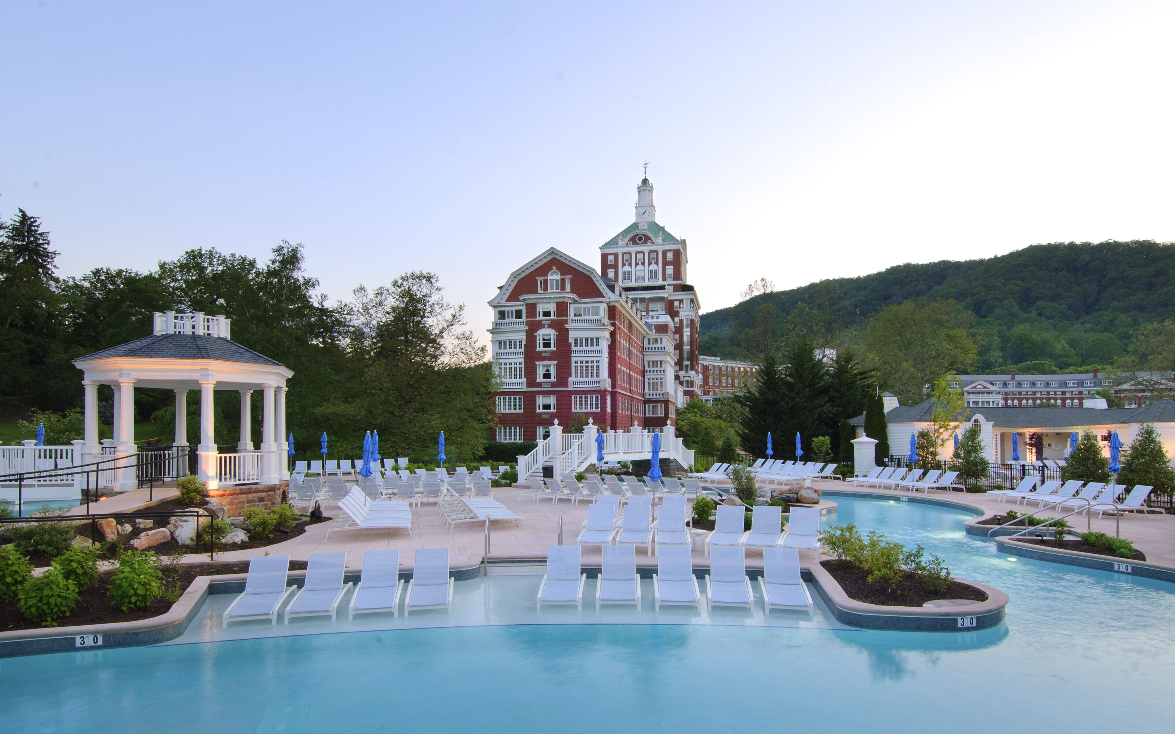 Uma área de piscina com espreguiçadeiras e um gazebo.