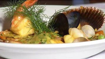 Prato de frutos do mar com concha de vieira, camarão, mexilhões e ervas.