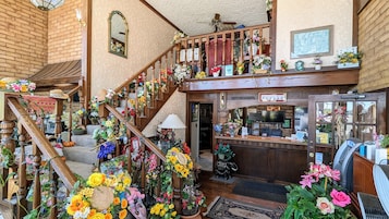 Uma escadaria com corrimãos de madeira decorados com flores e uma pequena loja na base.