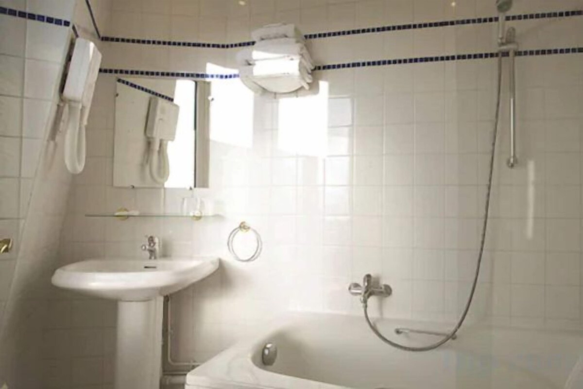 Casa de banho com lavatório, espelho e banheira.
