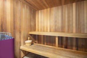 Uma sauna de madeira com bancos e uma pequena mesa de madeira.