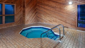 Interior de madeira com piscina, chão ladrilhado e luminária no teto.