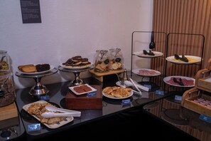 Buffet com diversos alimentos e utensílios.